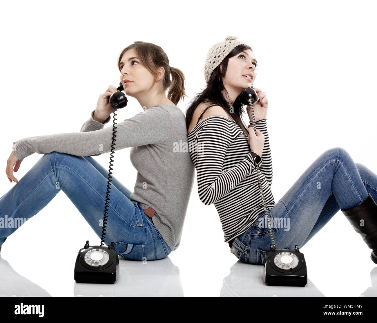 Two young women talking with old telephones - Isolated on white Stock ...