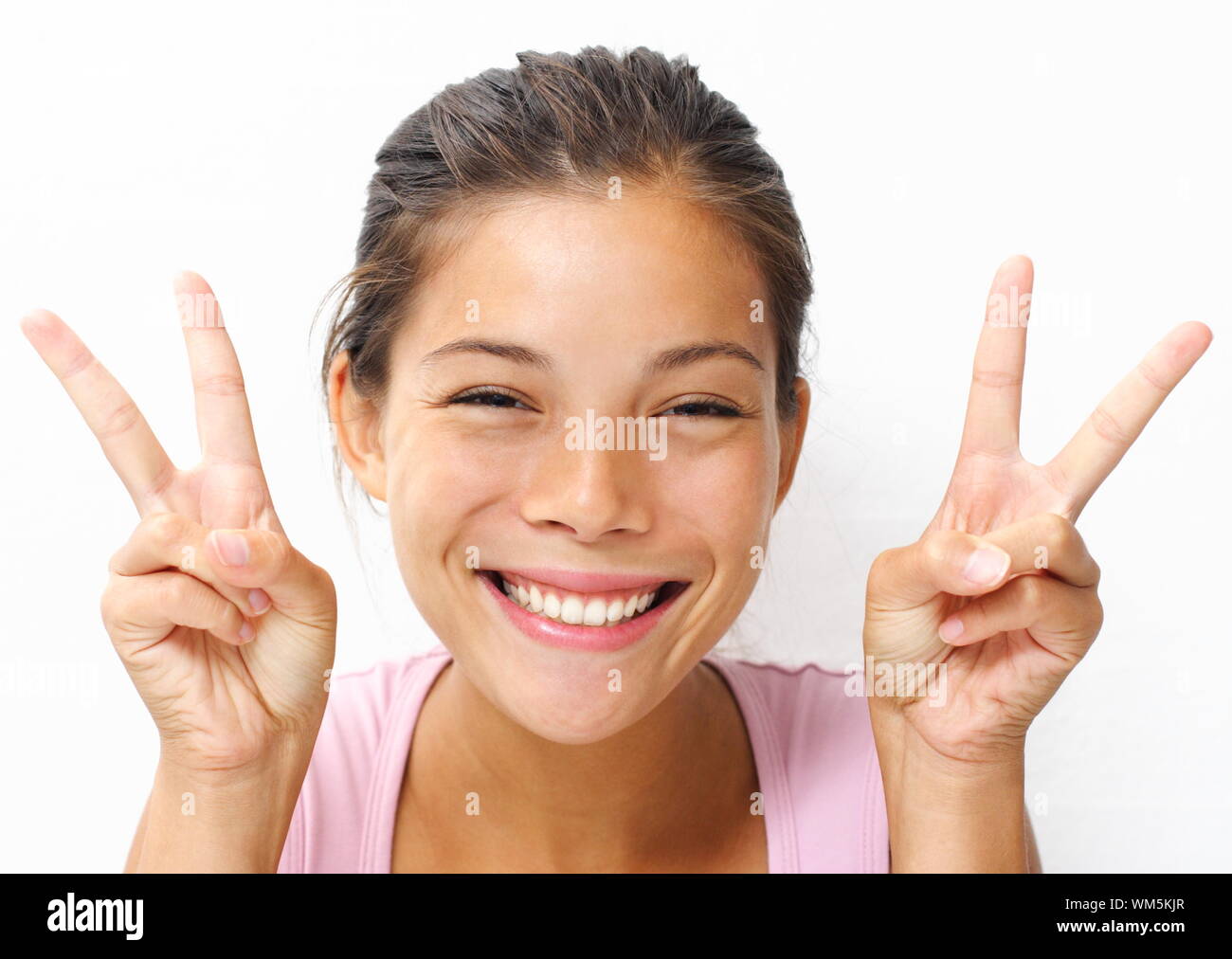 Cute young woman showing the peace / victory hand sign Stock Photo - Alamy