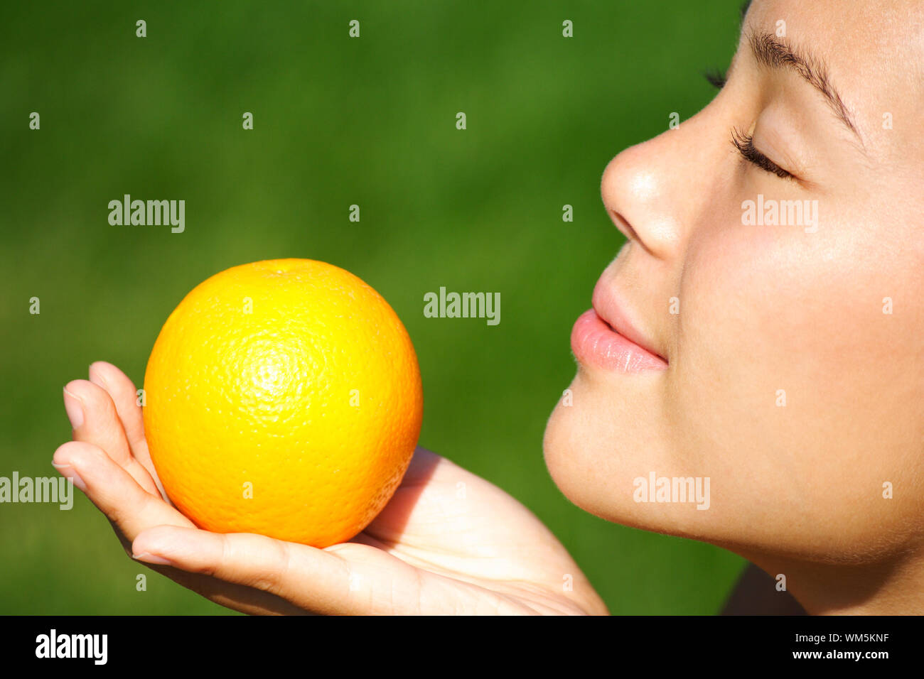 Woman smelling orange fruit hi-res stock photography and images - Alamy