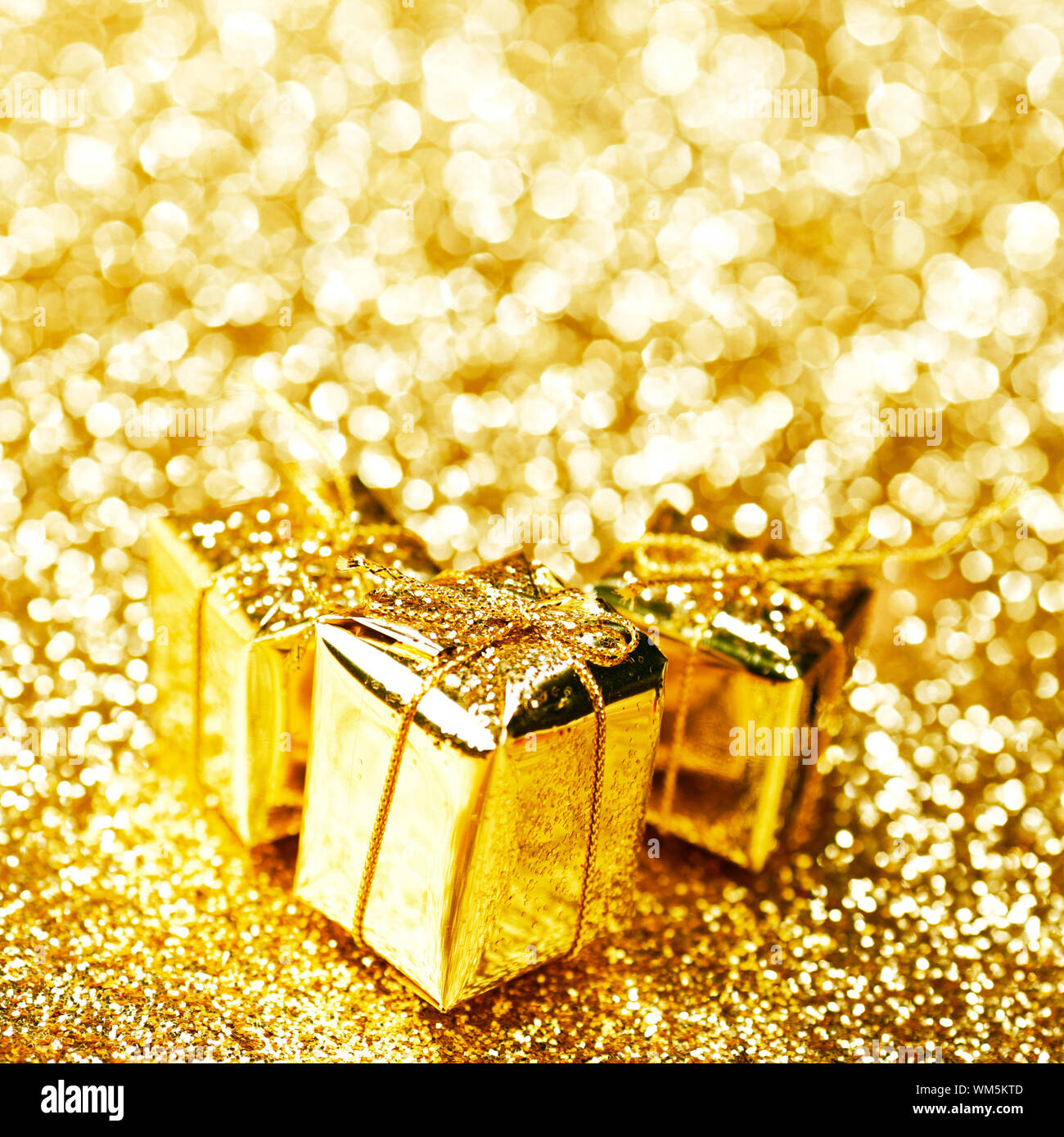 Decorative golden boxes with holiday gifts on shiny glitter background ...