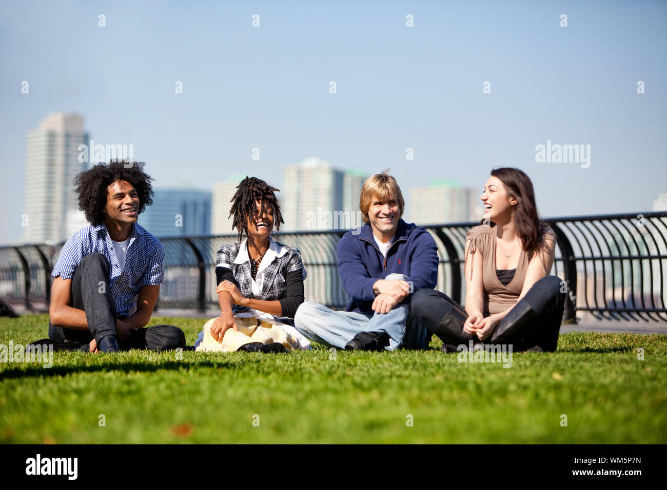 A group of friends in a city park talking and laughing Stock Photo - Alamy