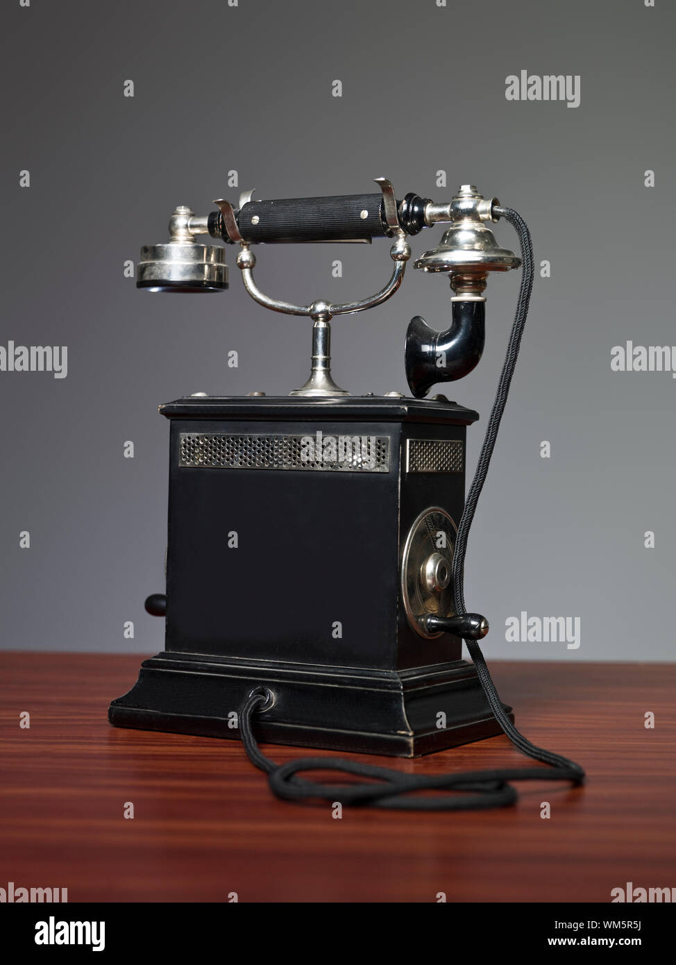 antique telephone on a desk against a grey background Stock Photo - Alamy