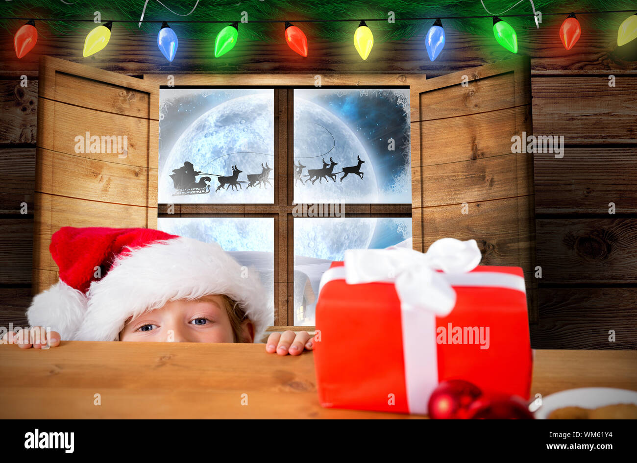 Festive boy peeking over table against santa delivery presents to ...