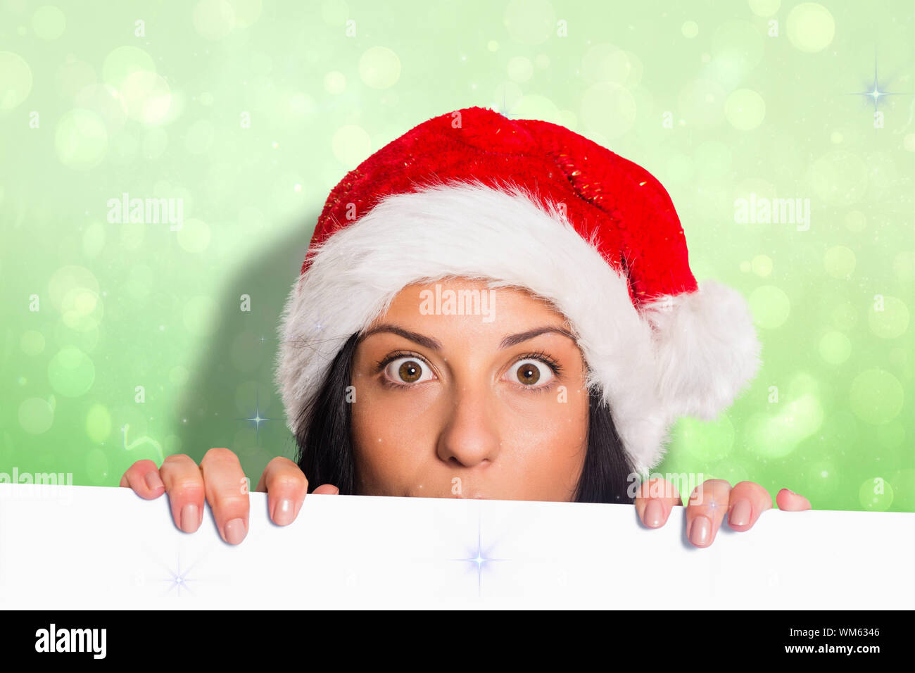 Woman surprised at the camera against green abstract light spot design ...