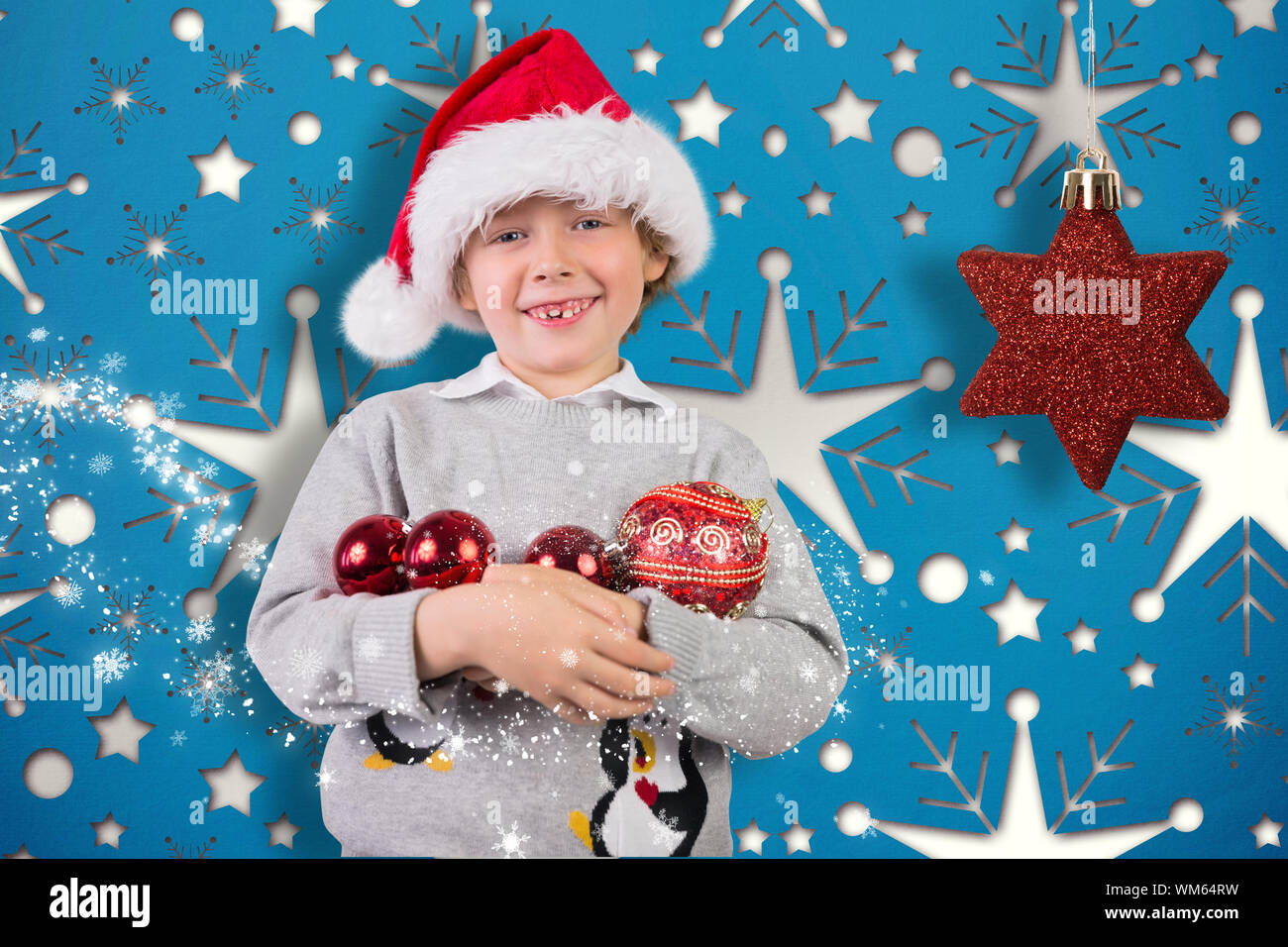 Festive boy smiling against snowflake wallpaper pattern Stock Photo - Alamy