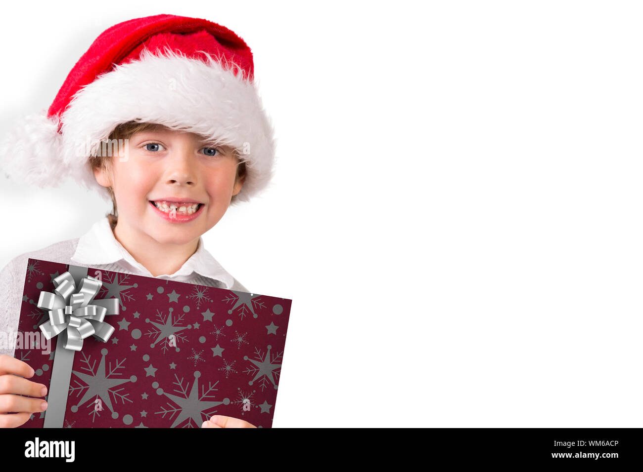 Festive boy showing letter against christmas wrapping paper with bow ...