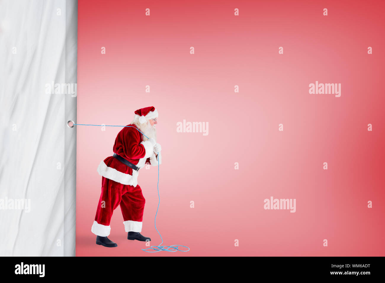 Santa claus pulling rope against red vignette Stock Photo - Alamy