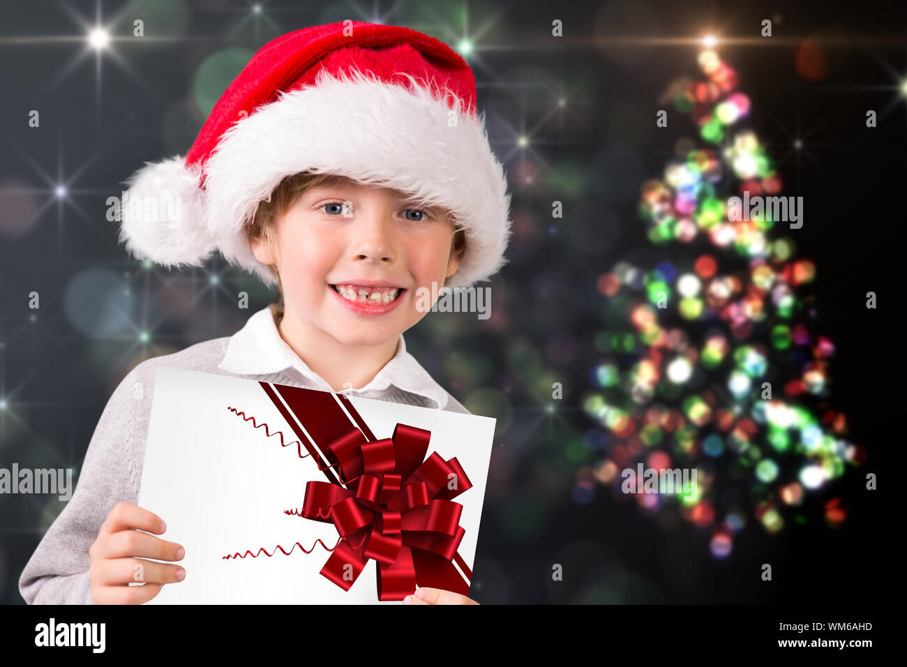 Festive boy showing letter against red christmas ribbon Stock Photo - Alamy