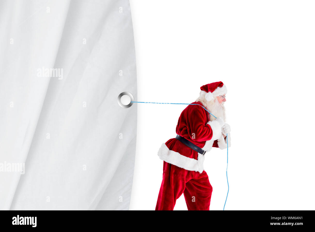 Santa claus pulling rope against white curtain blind Stock Photo - Alamy