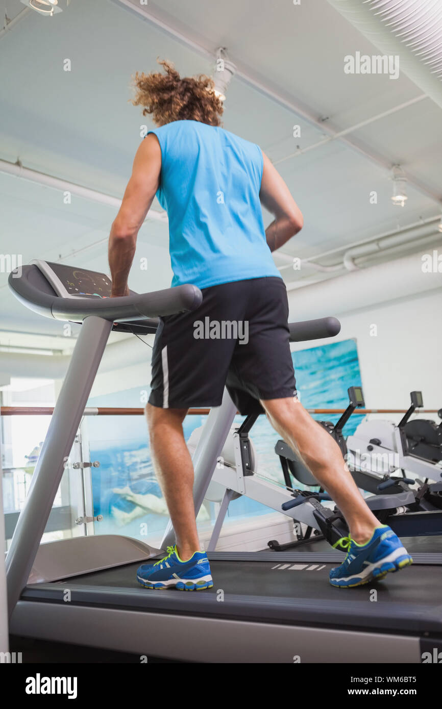 Rear view of a young man running on treadmill in the gym Stock Photo ...