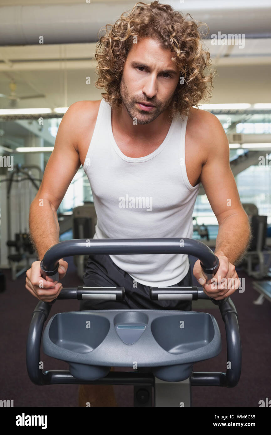 Fit man using exercise bike at the gym Stock Photo - Alamy