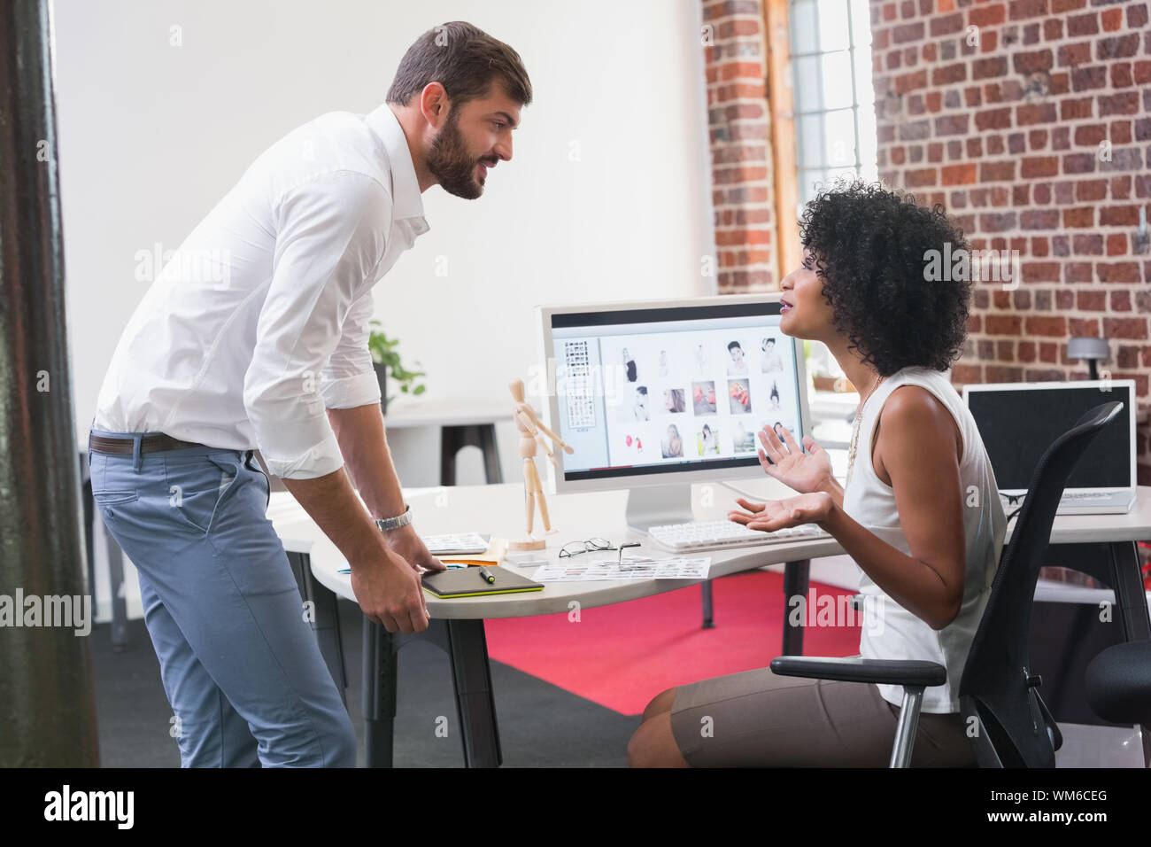 Side view of two photo editors in discussion at the office Stock Photo ...