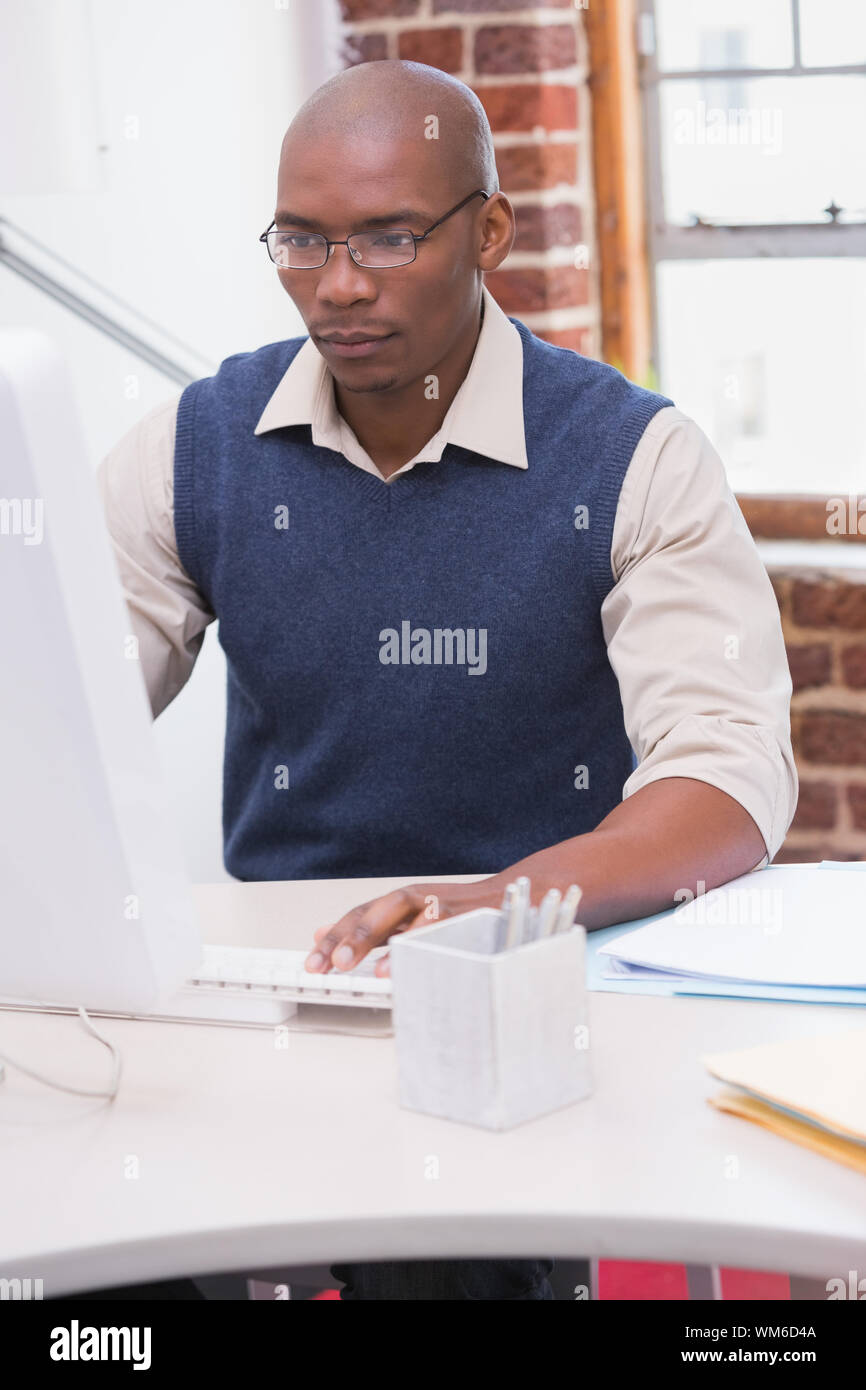 Serious young businessman looking at computer monitor in office Stock ...