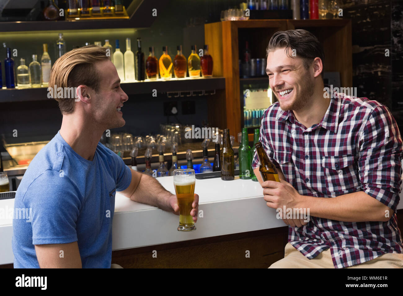 Young men drinking beer together at the bar Stock Photo - Alamy