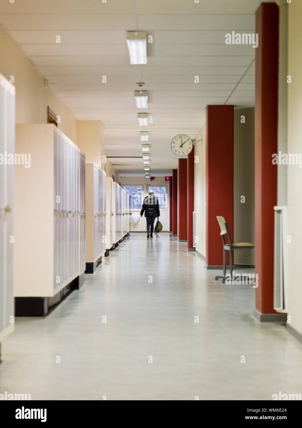 Young woman walking away through a corridor at school Stock Photo - Alamy