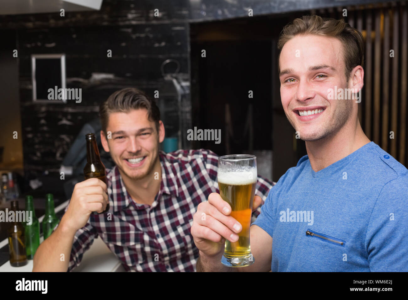 Young men drinking beer together at the bar Stock Photo - Alamy