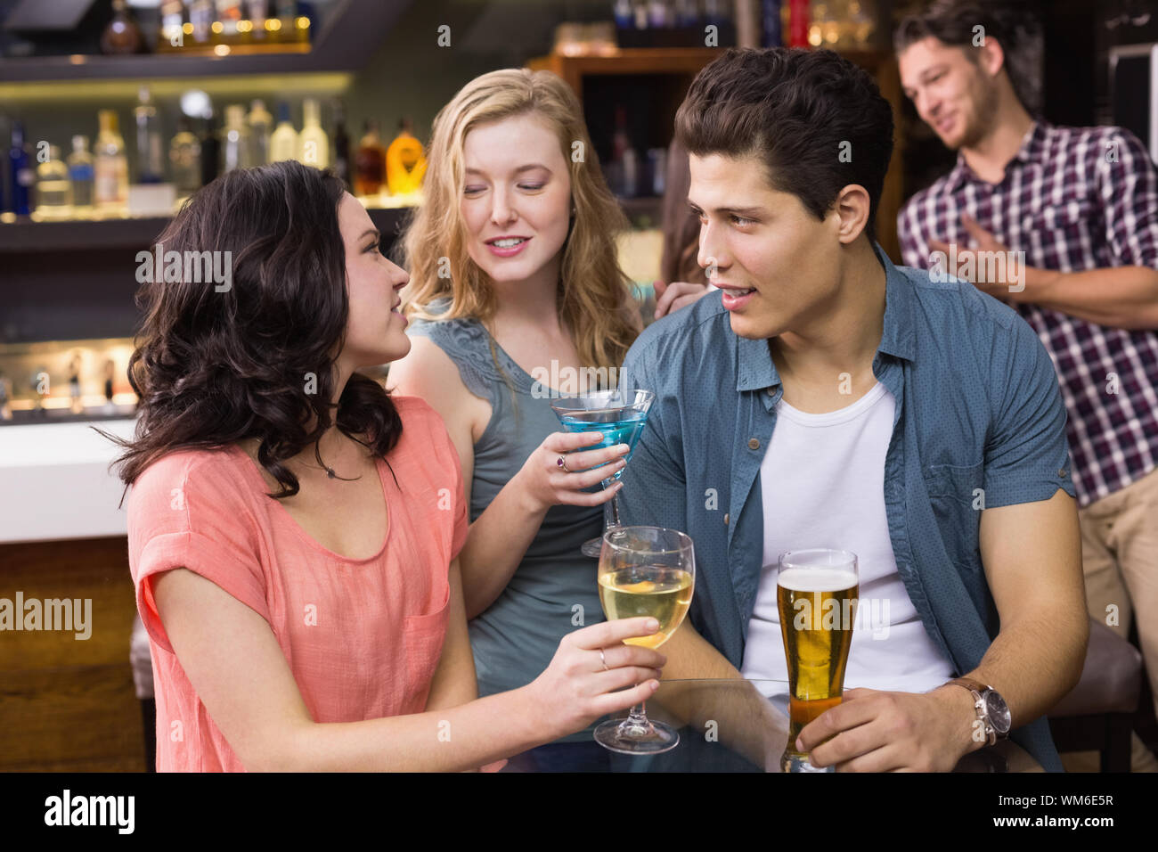 Young friends having a drink together at the bar Stock Photo - Alamy