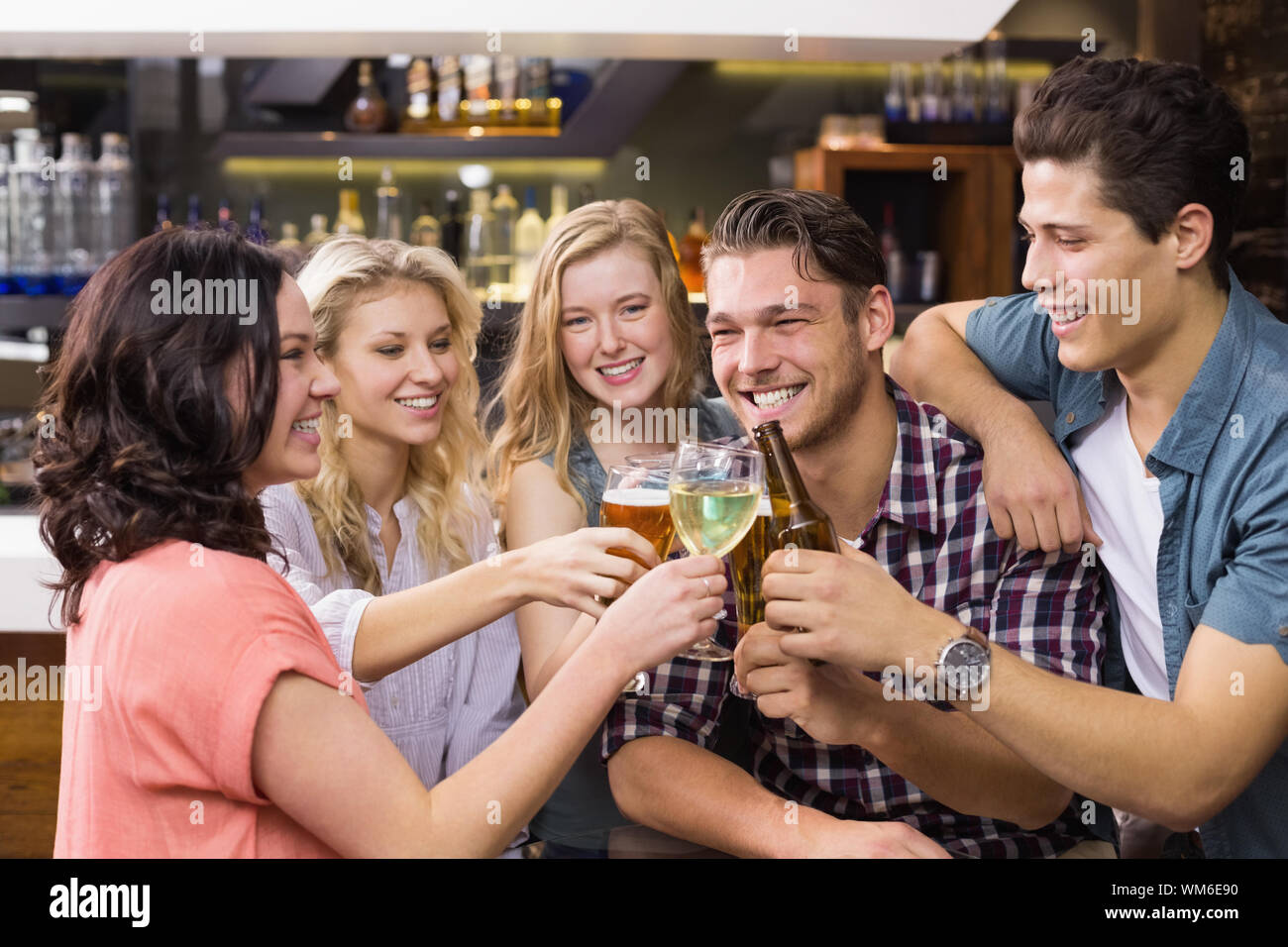 Smiling friends interacting having beer hi-res stock photography and ...