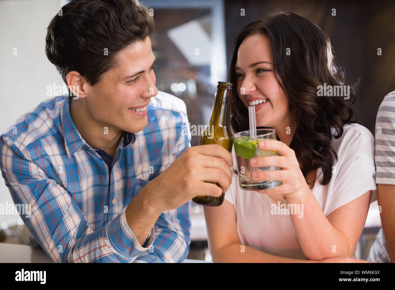 Happy friends having a drink together at the bar Stock Photo - Alamy