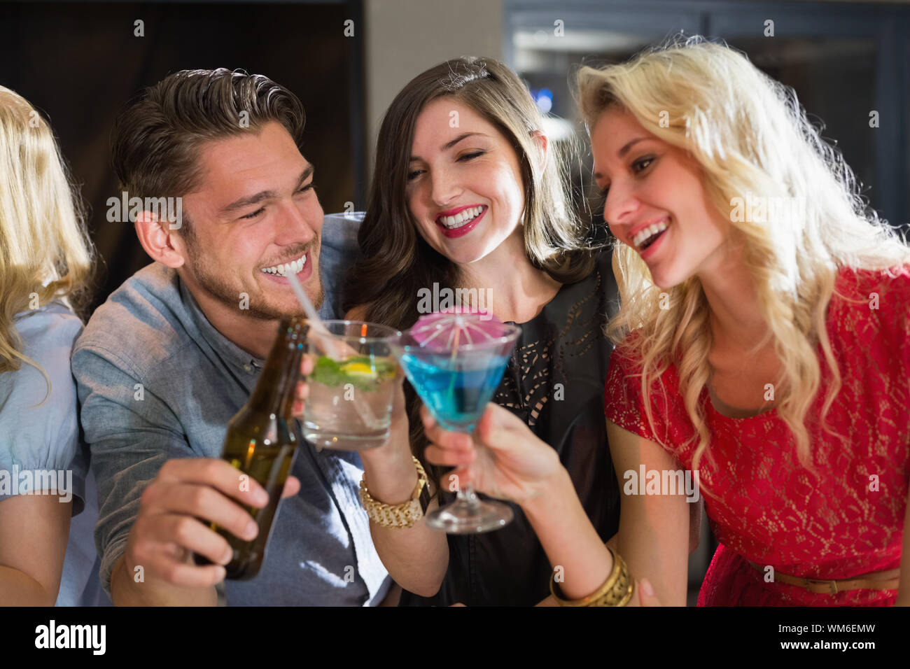 Happy friends having a drink together at the bar Stock Photo - Alamy