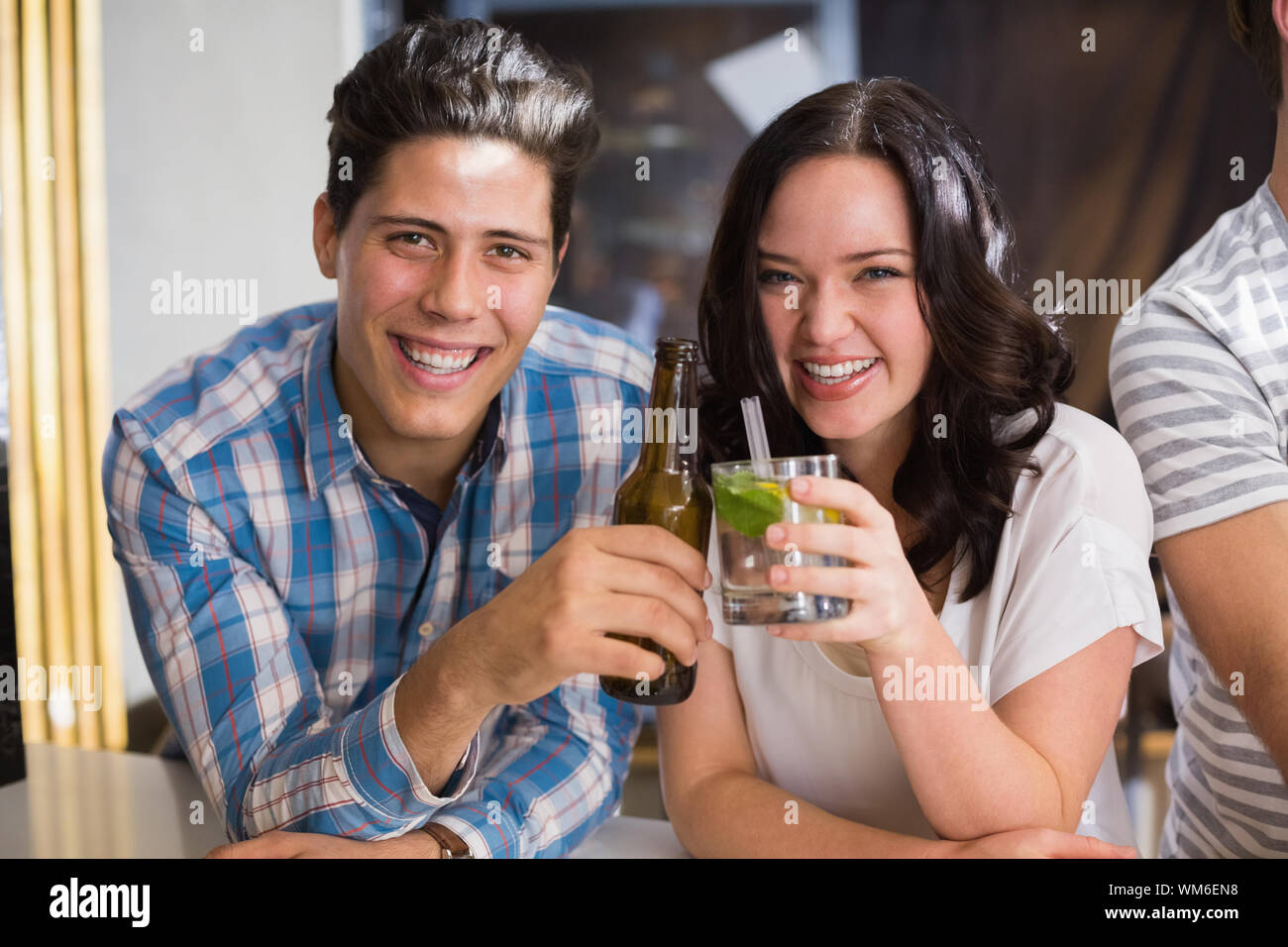Happy friends having a drink together at the bar Stock Photo - Alamy