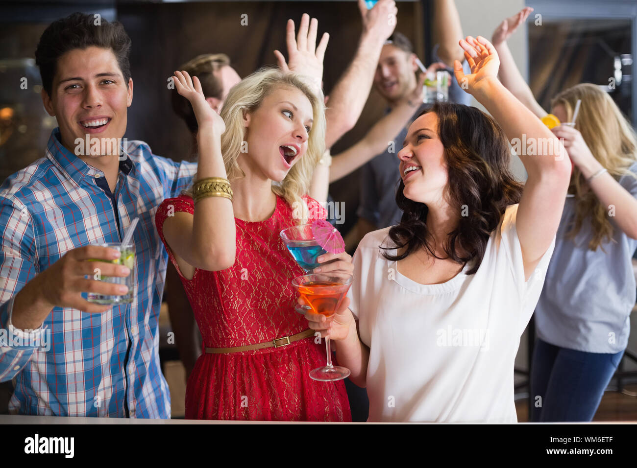 Young friends having a drink together at the bar Stock Photo - Alamy