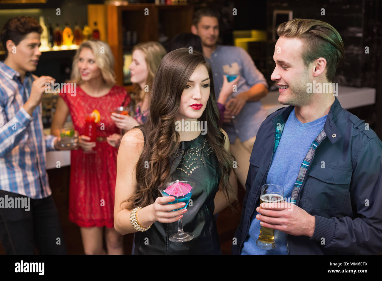Happy friends having a drink together at the bar Stock Photo - Alamy