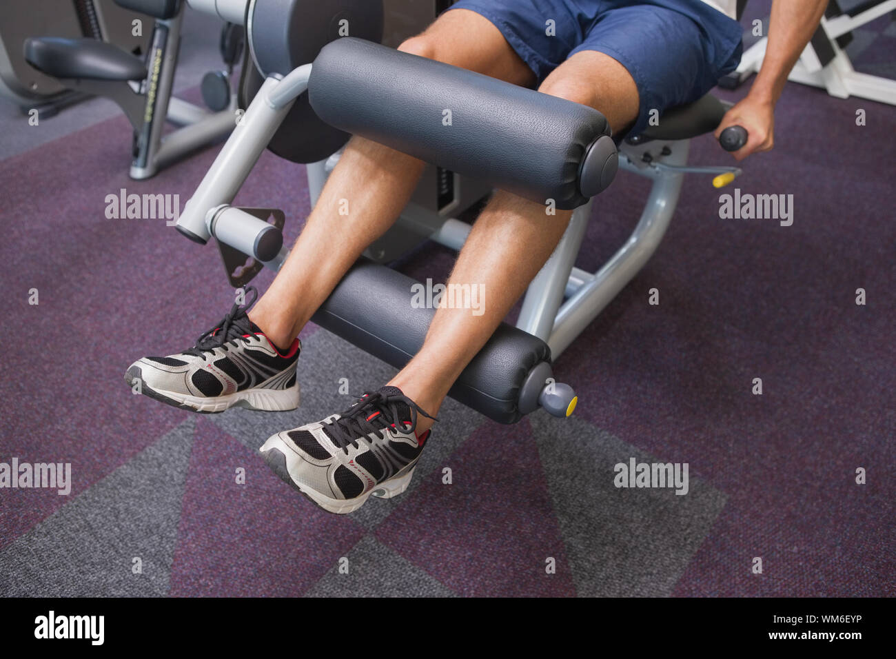 Fit man using weights machine for legs at the gym Stock Photo - Alamy