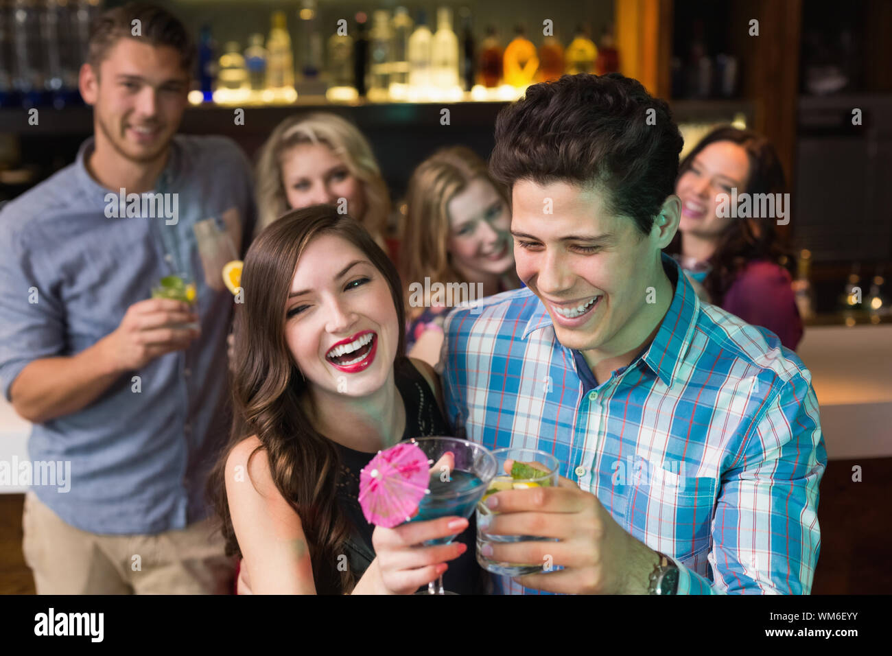Happy friends drinking cocktails together at the bar Stock Photo - Alamy