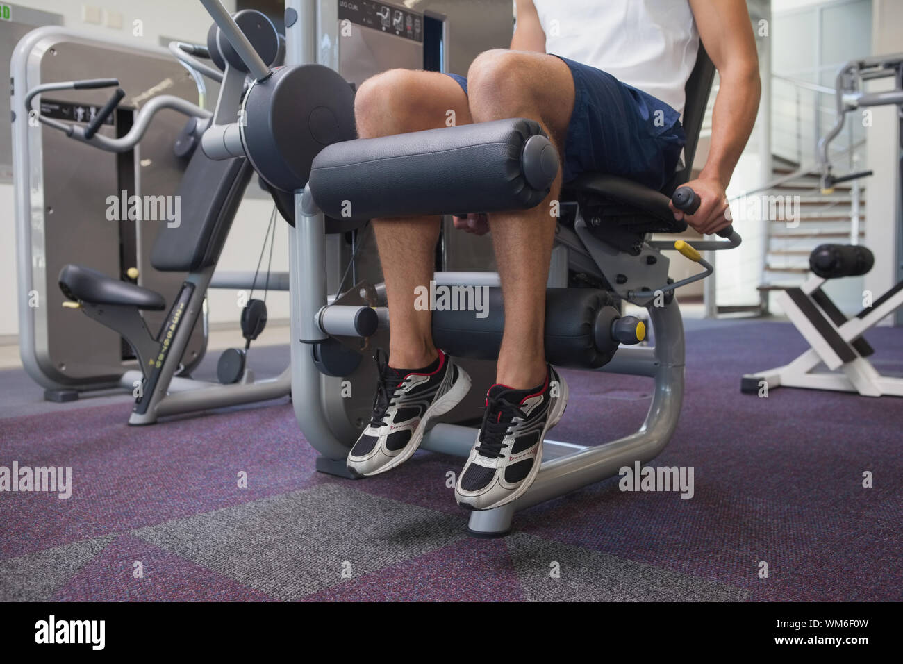 Fit man using weights machine for legs at the gym Stock Photo - Alamy