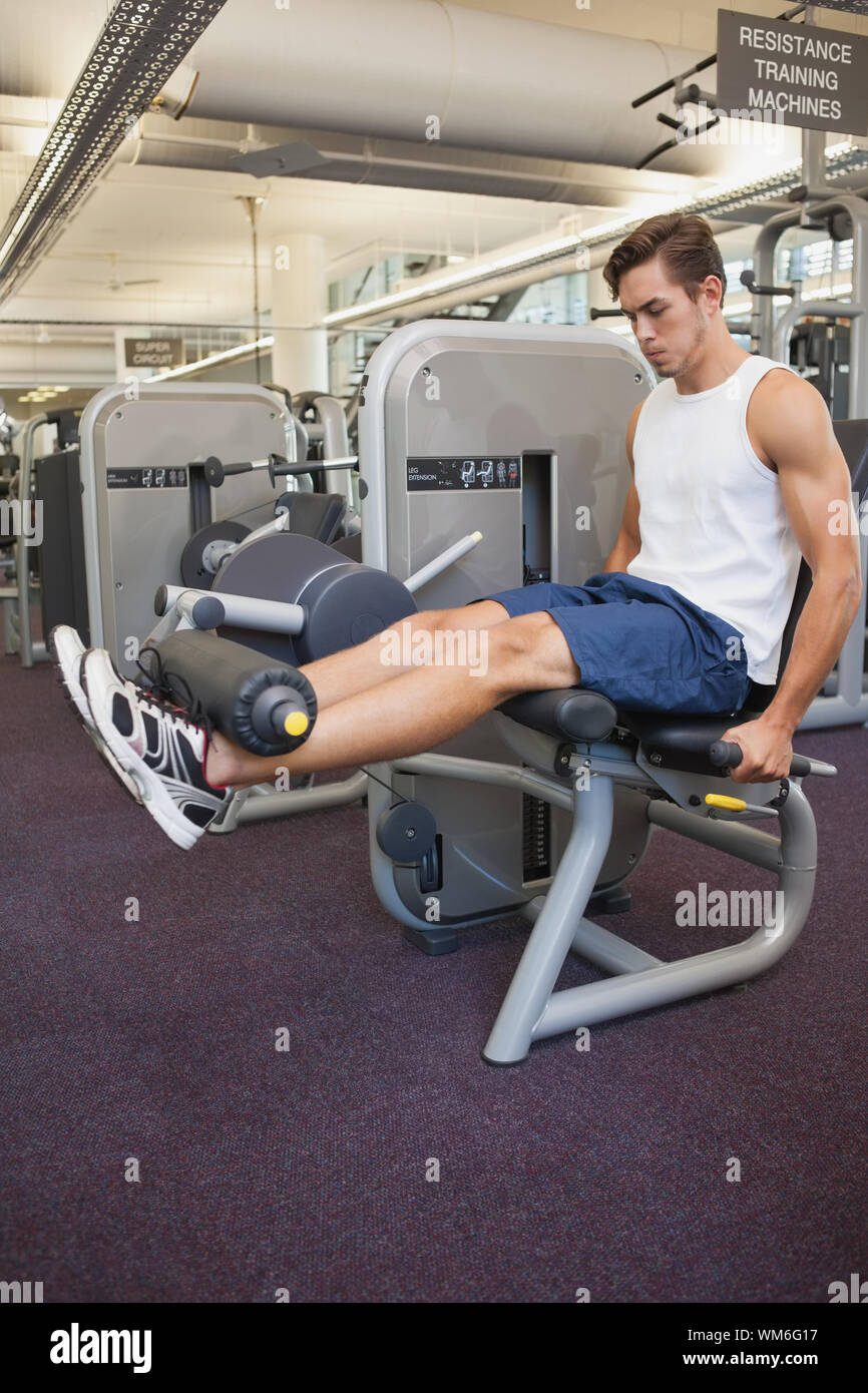 Fit man using weights machine for legs at the gym Stock Photo - Alamy