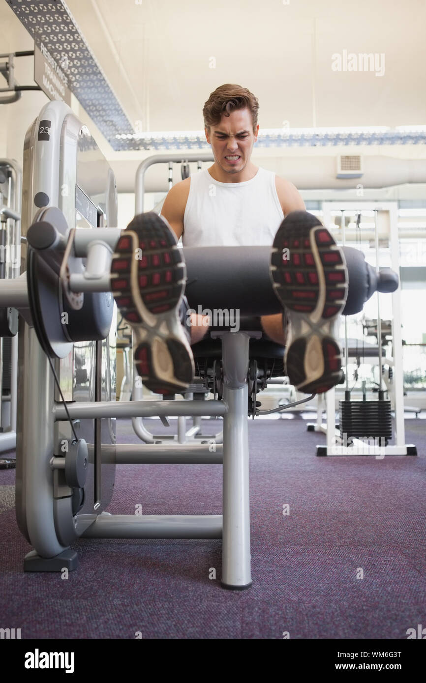 Fit man using weights machine for legs at the gym Stock Photo - Alamy