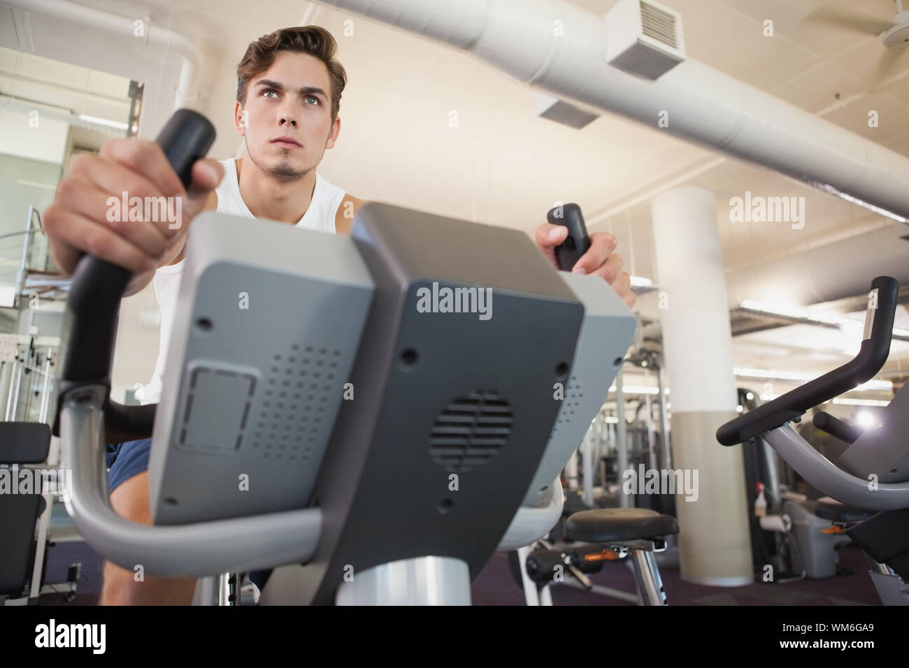 Fit man working out on the exercise bike at the gym Stock Photo - Alamy