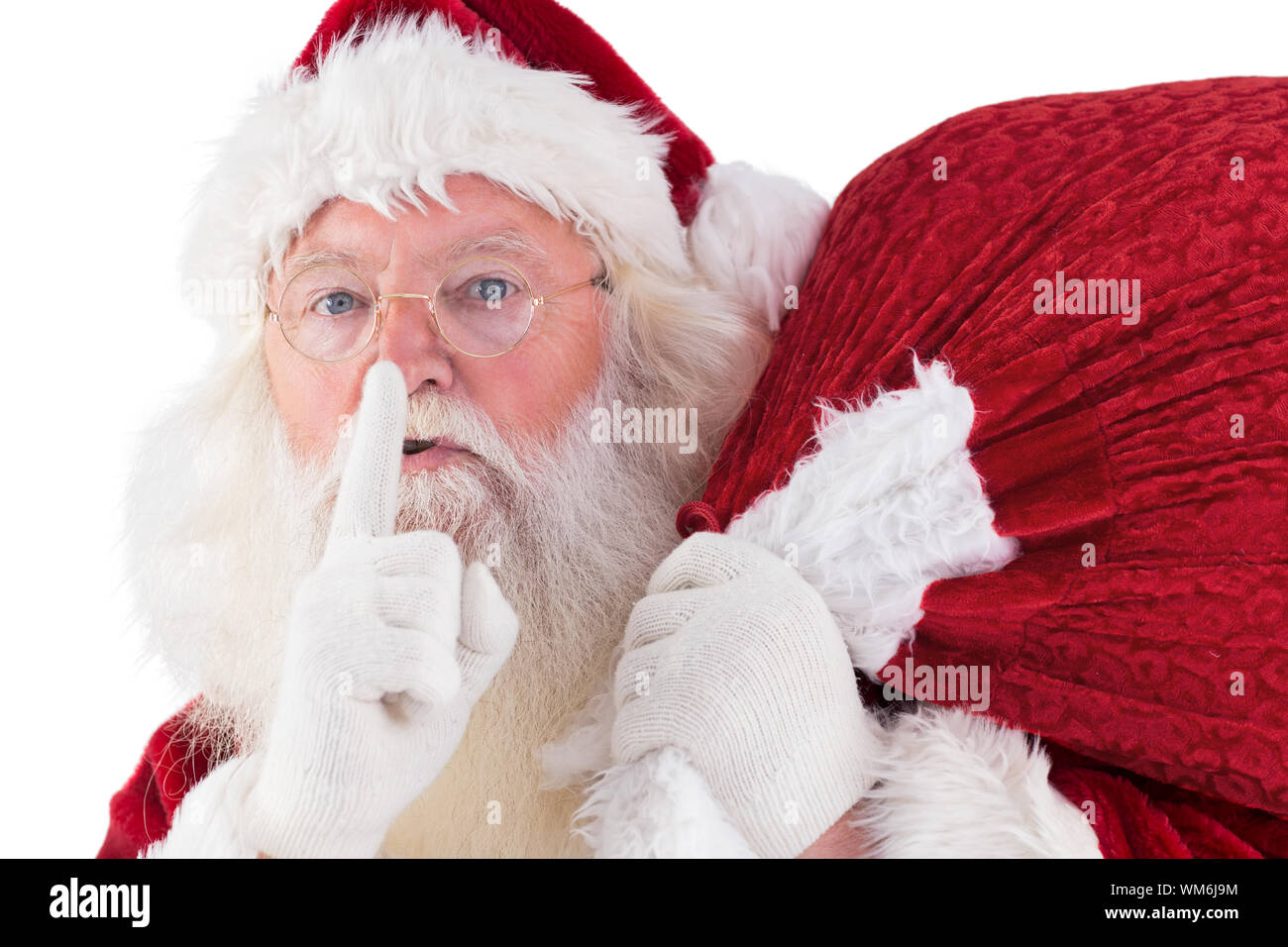 Santa asking for quiet with bag on white background Stock Photo - Alamy