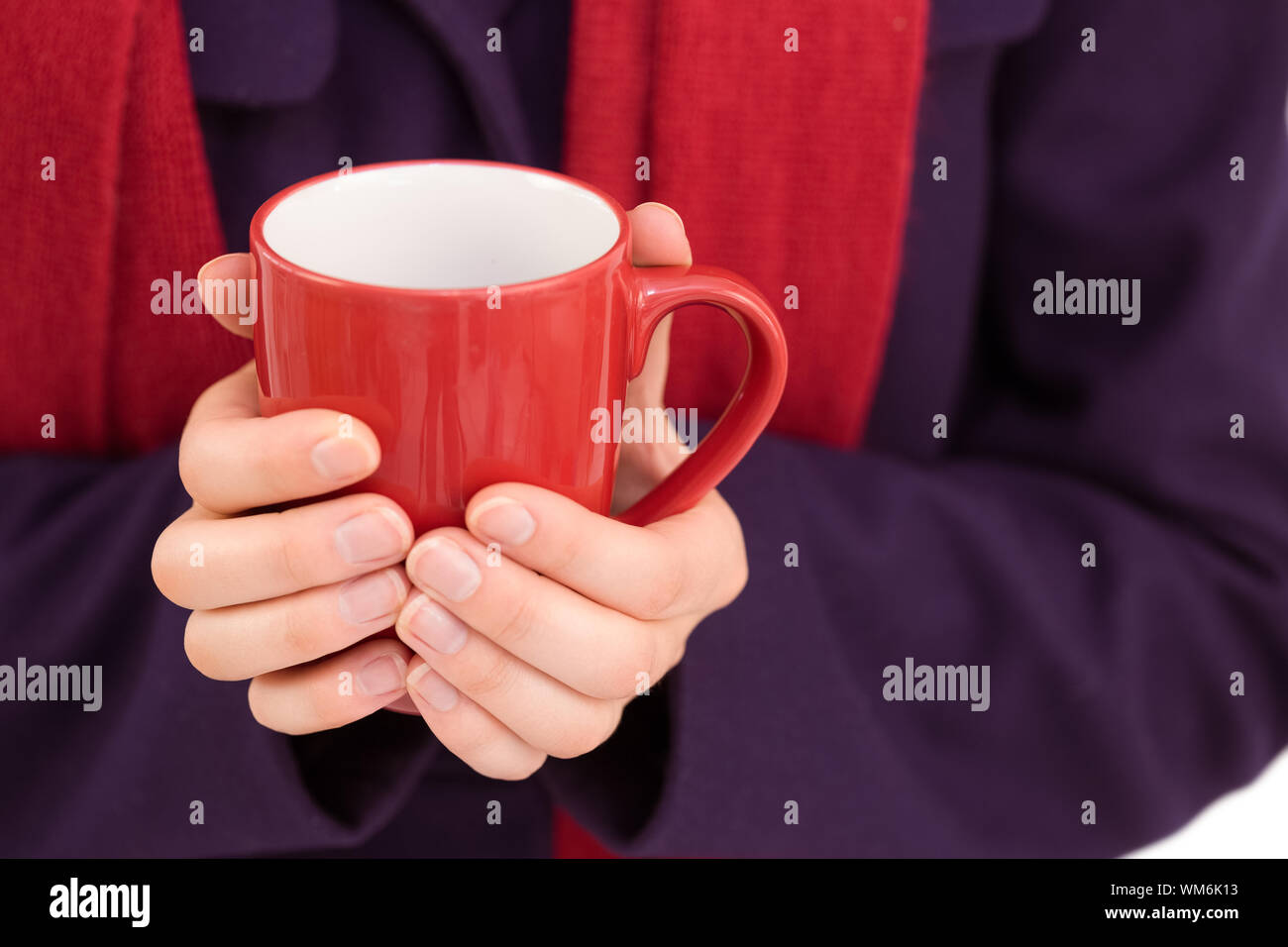 Close up of a woman in warm clothing holding mug on white background ...