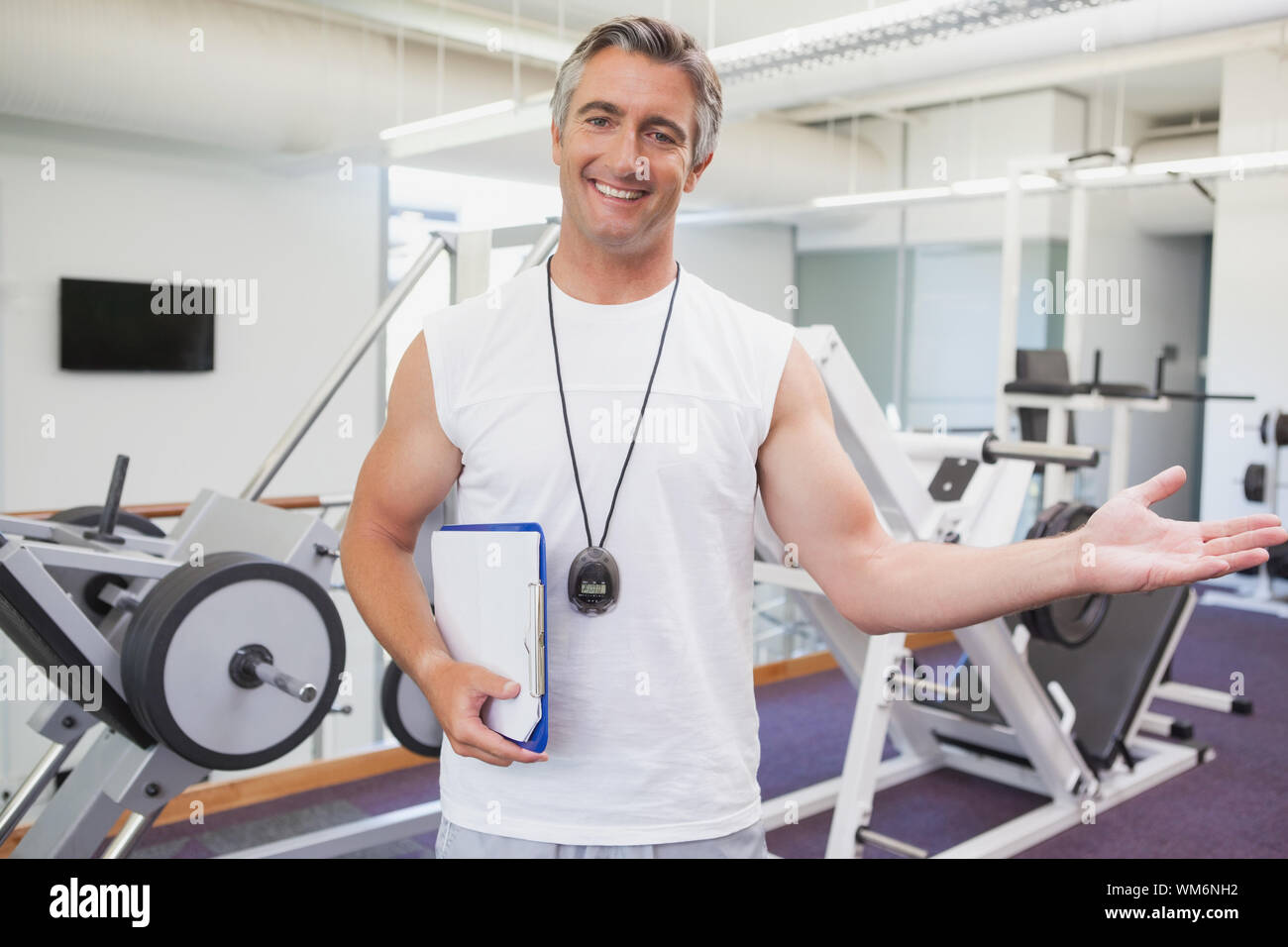 Fit personal trainer smiling at camera in fitness studio at the gym ...