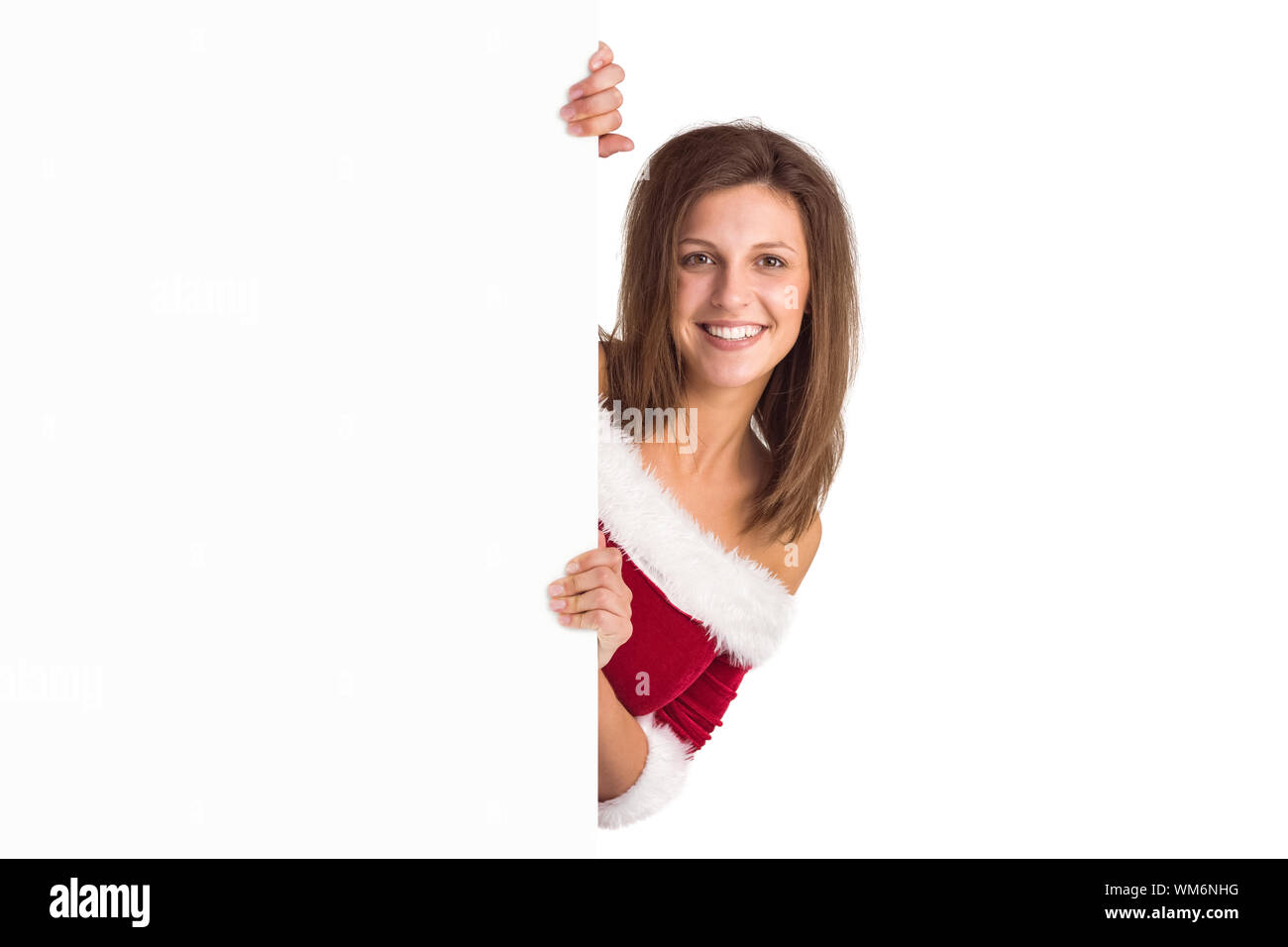 Pretty santa girl smiling at camera behind poster on white background ...