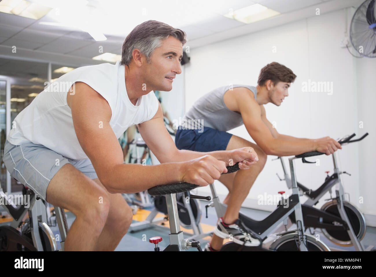 Fit people working out on the exercise bikes at the gym Stock Photo - Alamy