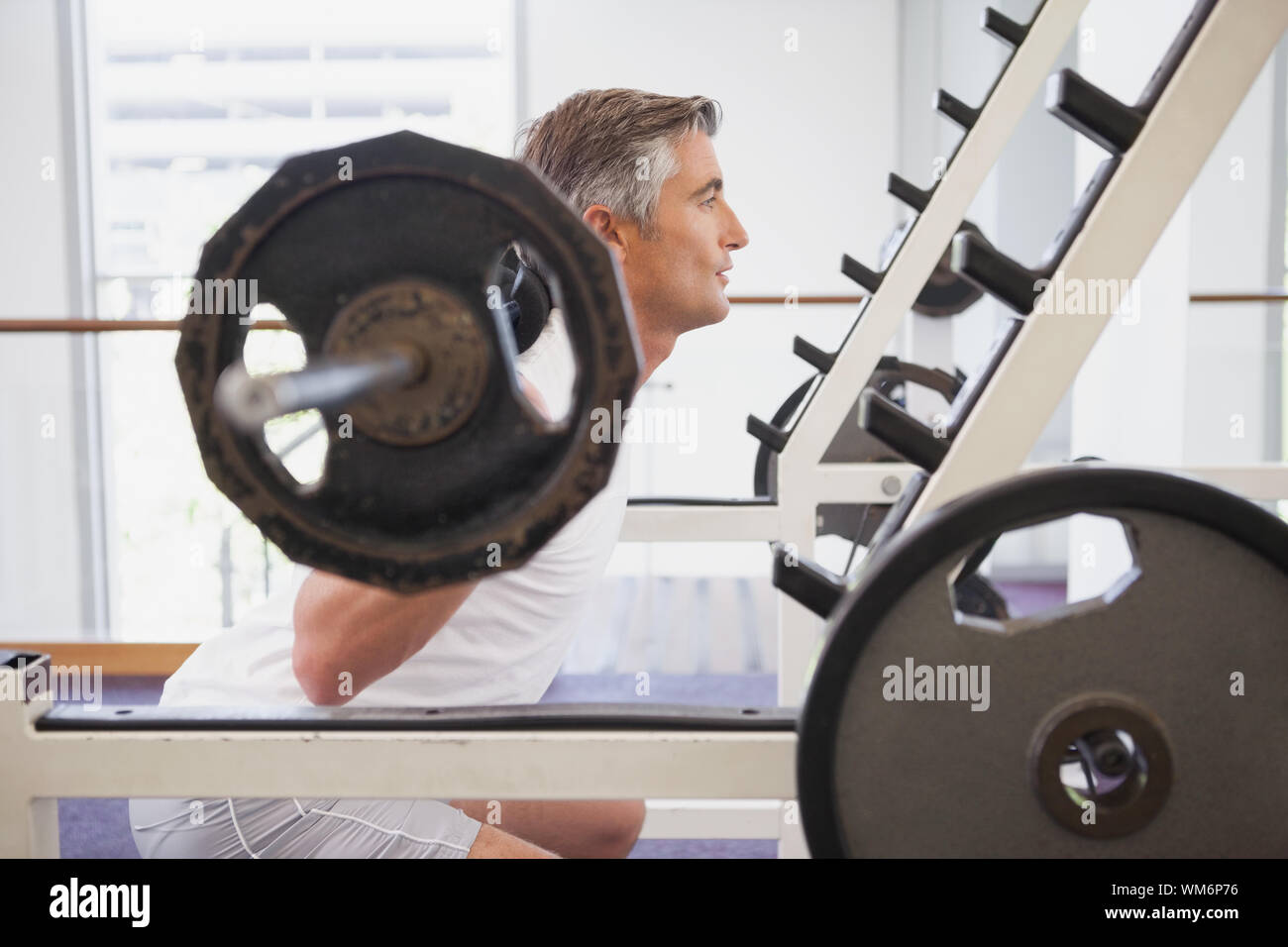 Fit man lifting heavy barbell at the gym Stock Photo - Alamy