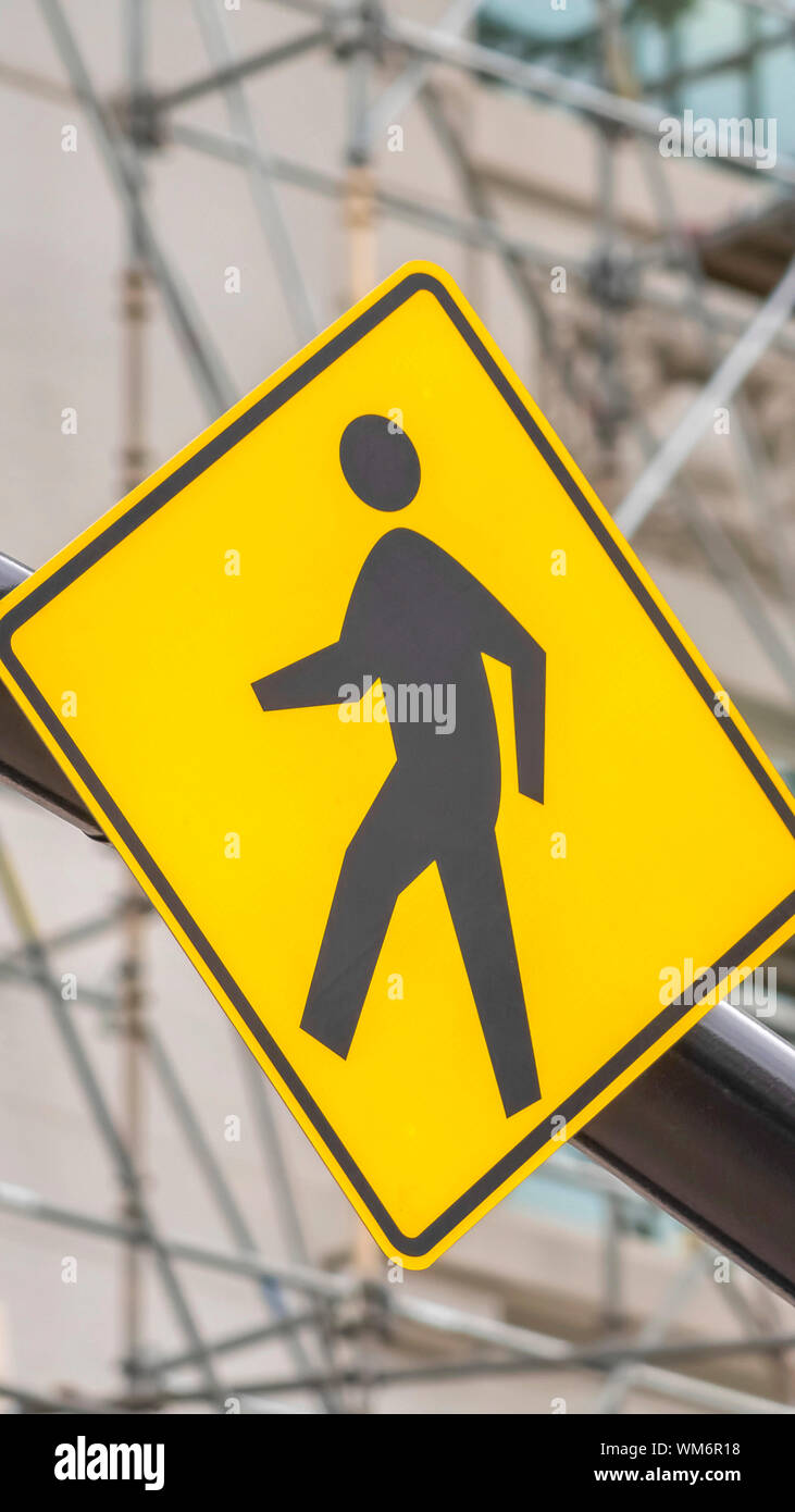 Vertical Close up view of a yellow and black diamond shaped Pedestrian ...