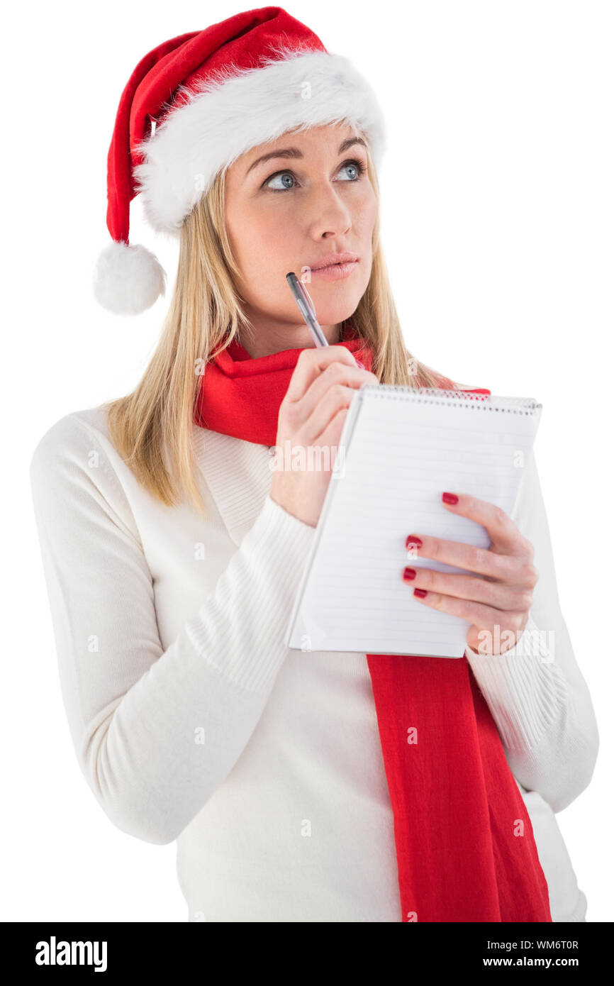 Festive blonde writing her christmas list on white background Stock ...