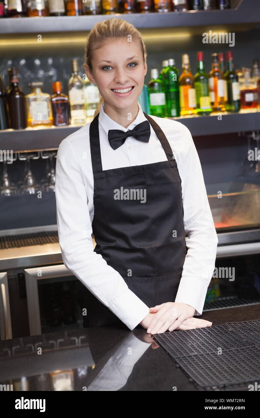 Pretty waitress smiling at the camera in a bar Stock Photo - Alamy
