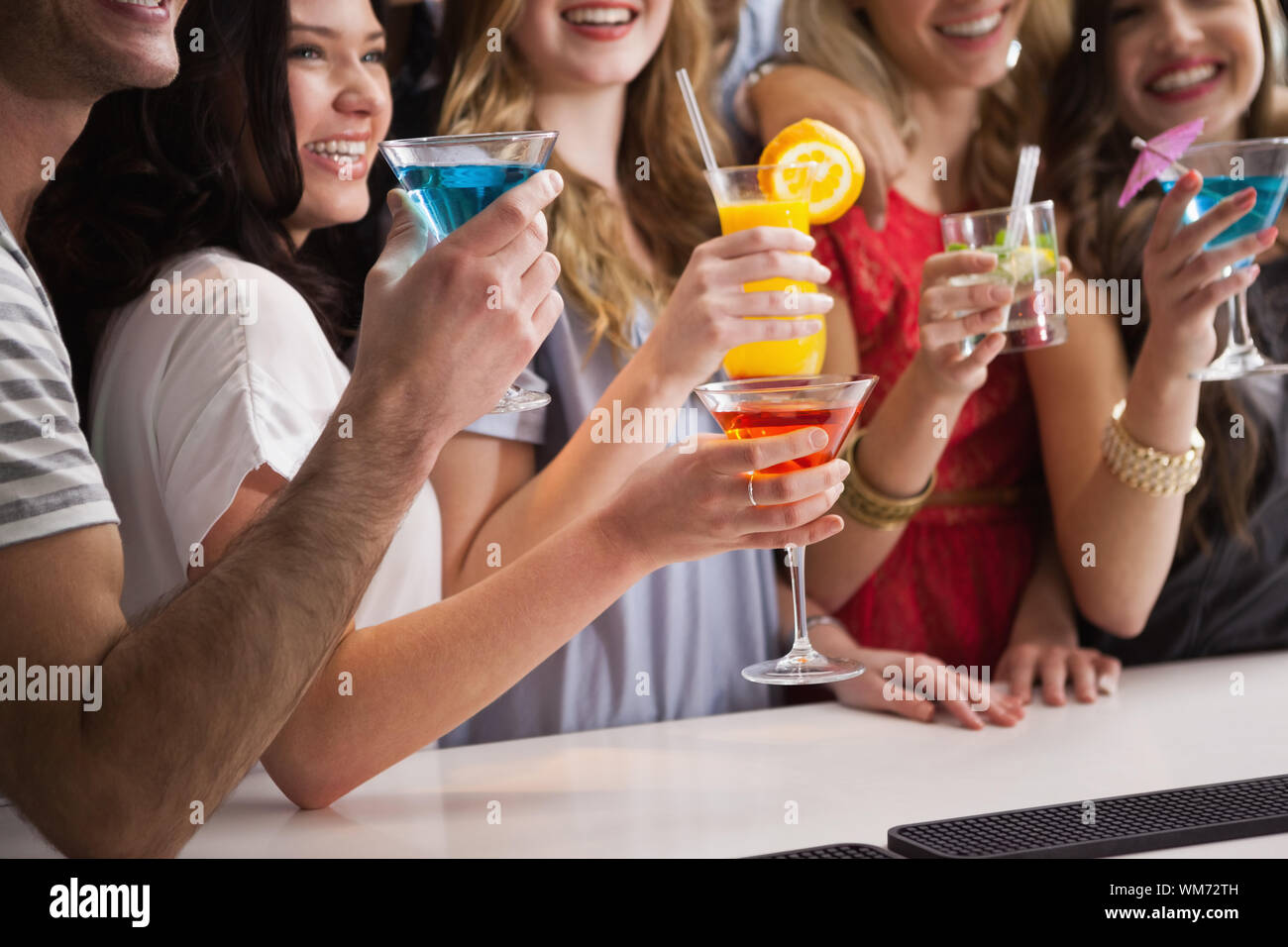 Happy friends having a drink together in a bar Stock Photo - Alamy