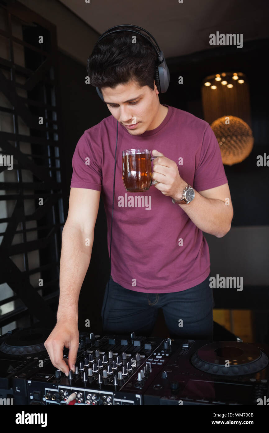 Handsome focused dj moderating turning up volume at the nightclub Stock ...