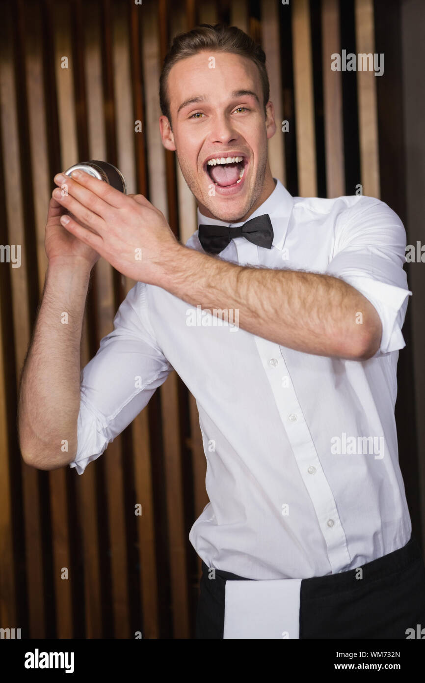 Happy waiter shaking drink in cocktail shaker in a bar Stock Photo - Alamy
