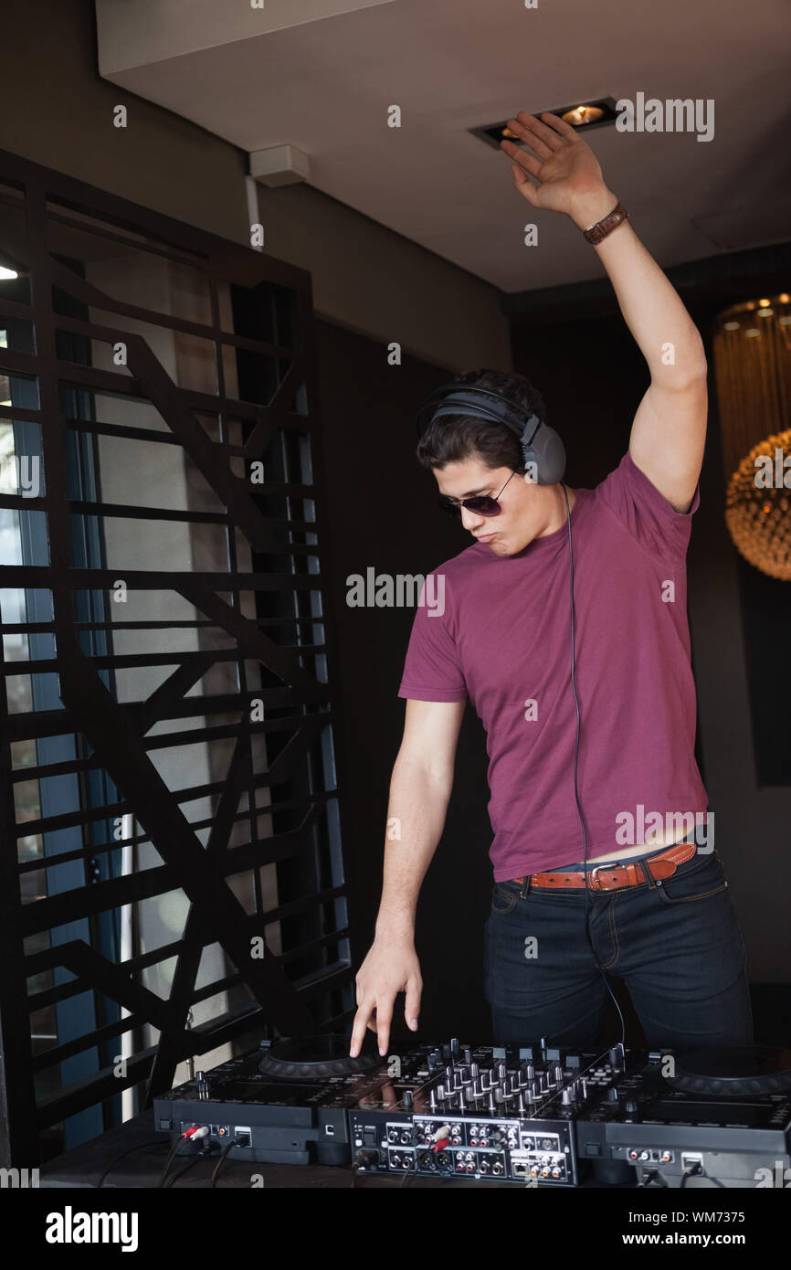 Cool dj in sunglasses mixing with hand up at the nightclub Stock Photo ...