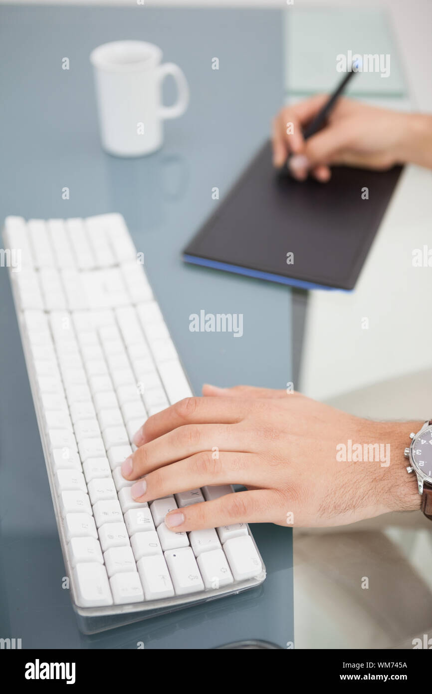 Designer using digitizer and typing on keyboard in his office Stock ...