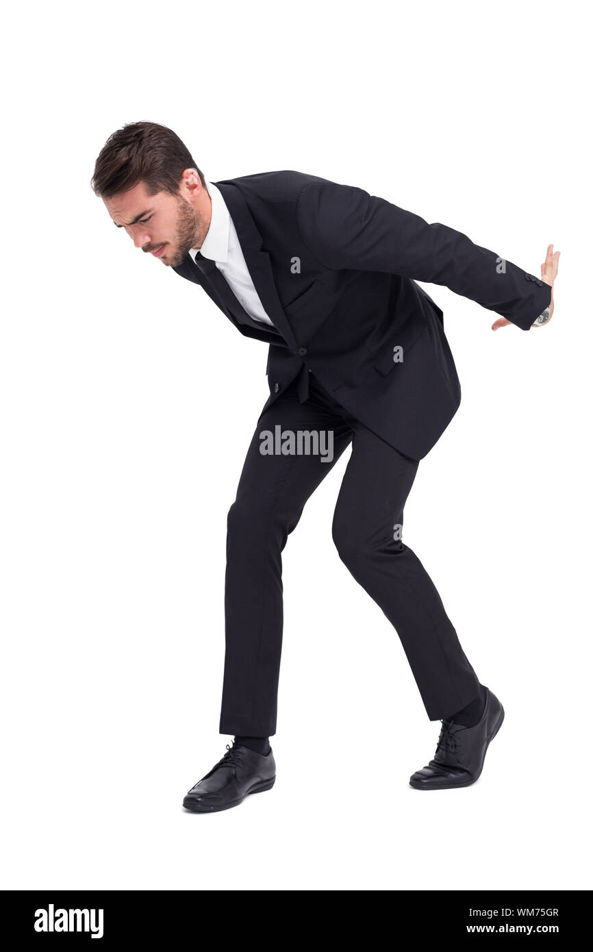 Businessman carrying something heavy with his back and hands on white ...