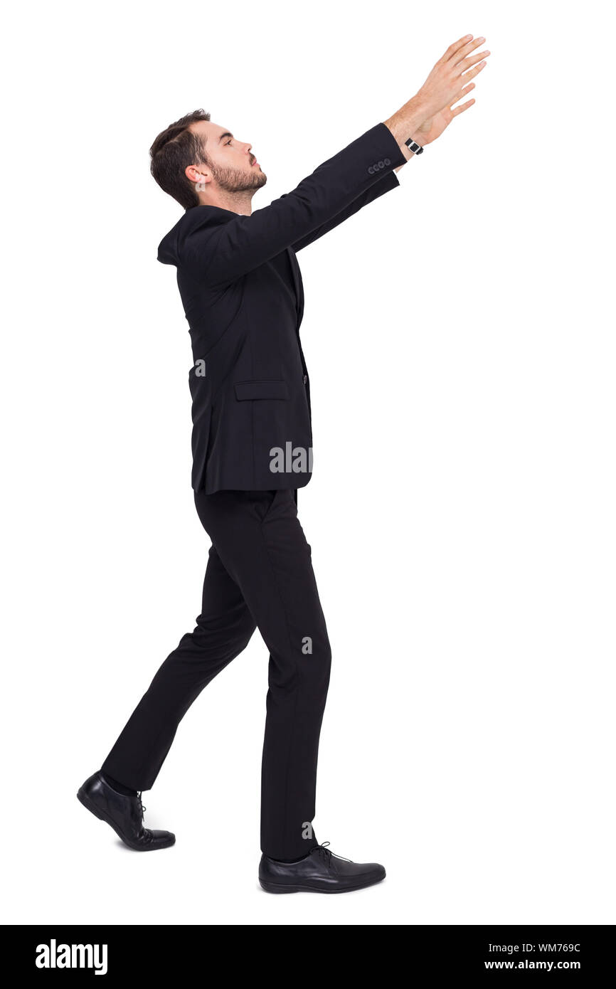 Businessman with arms raised catching something on white background ...