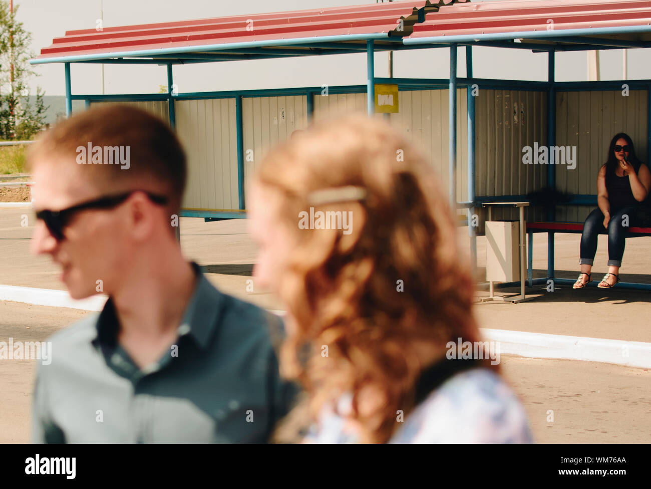 Sitting on bus stop bench hi-res stock photography and images - Alamy